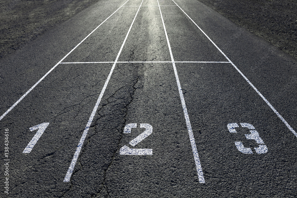 Sunny straight race asphalt road with painted lines and first, second ...