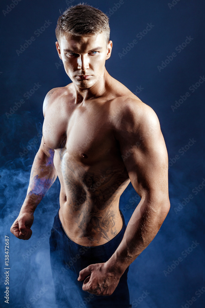 Handsome power athletic man bodybuilder. Fitness muscular body on dark ...