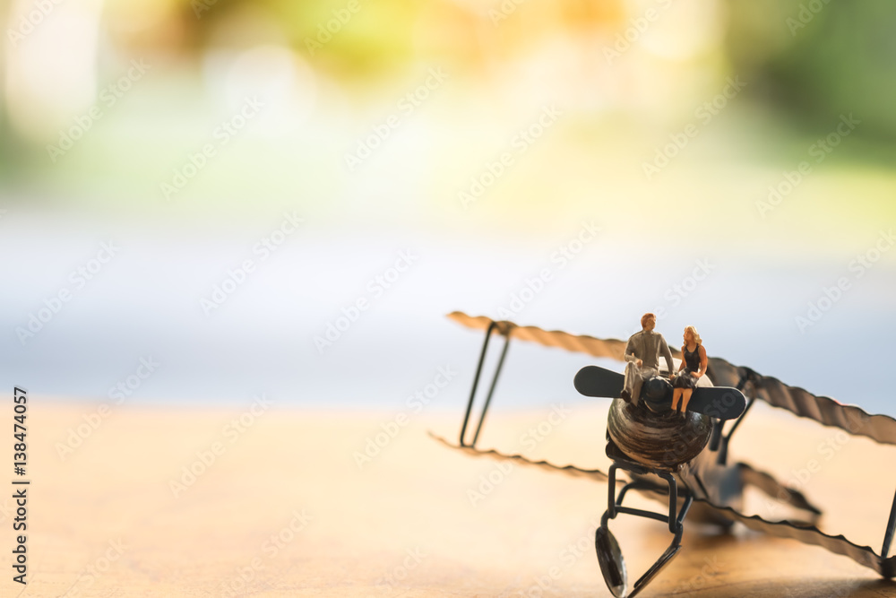 Miniature people : young couple sitting vintage airplane for travelling ...