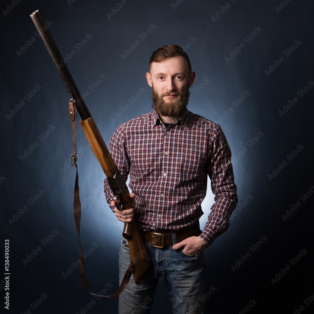 Man holding a shotgun Stock Photo | Adobe Stock
