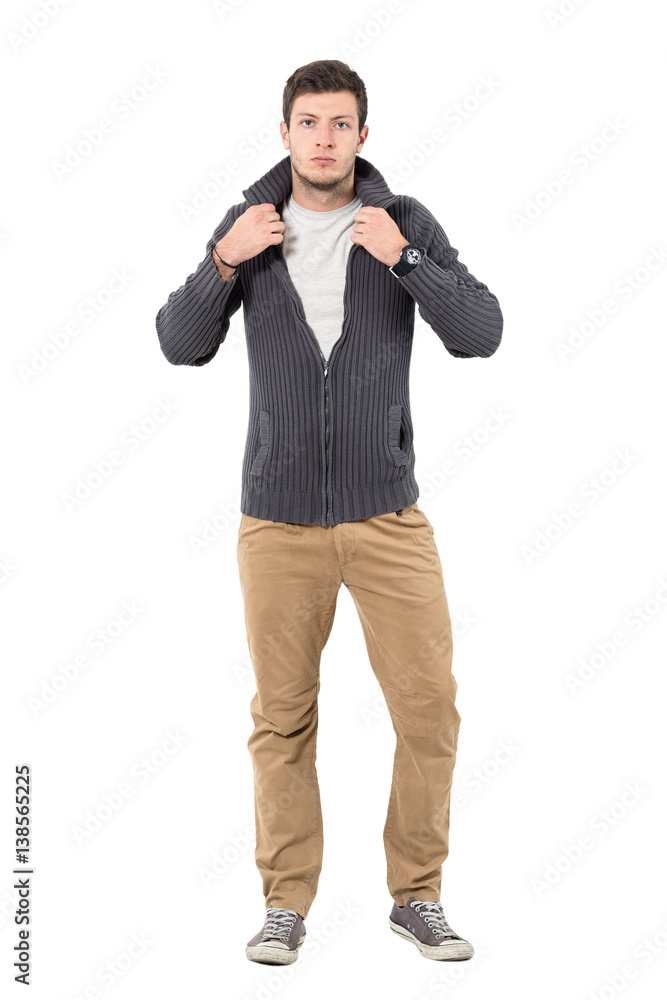 Serious handsome man get dressed adjusting sweater collar looking at ...