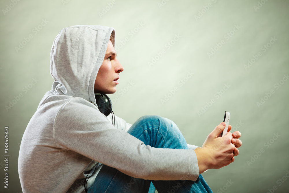 Hooded man with headphones listening music Stock Photo | Adobe Stock