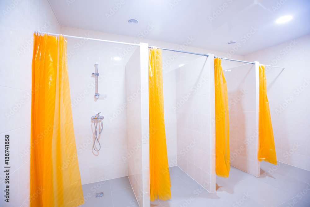 Public shower room with several showers. Big, light, empty public ...
