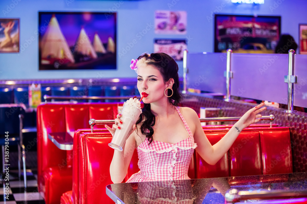 Portrait d'une jeune Pin'Up, dégustant joyeusement son milkshake Stock ...