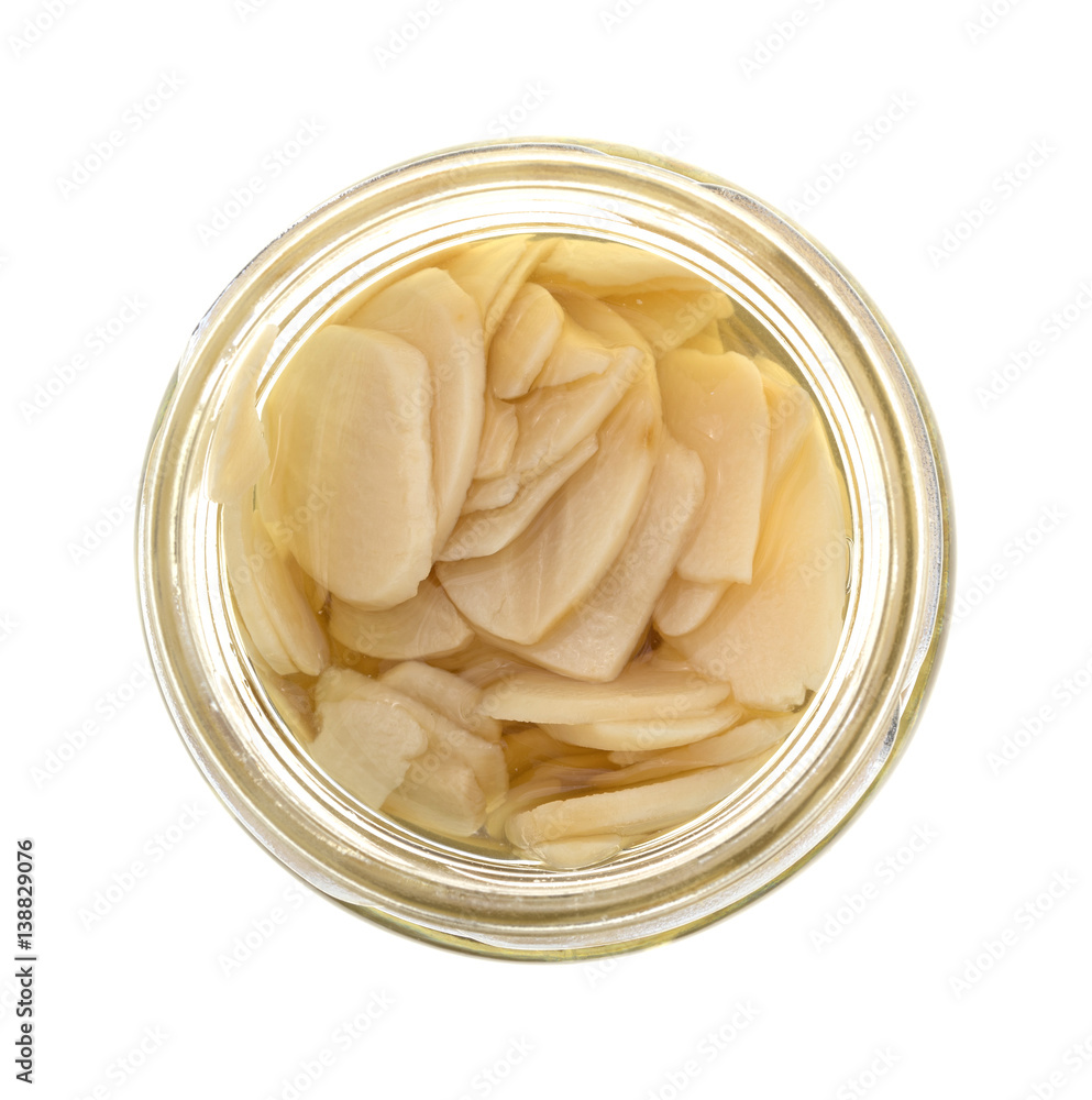 Sliced garlic in an opened glass jar isolated on a white background ...