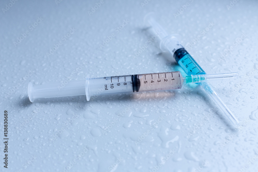 Syringe with solution and have rain drops water on table in Laboratory ...