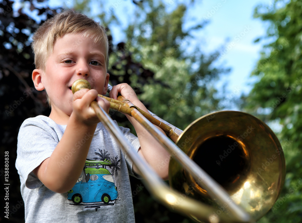 Boy playing the golden trombone outdoors Stock Photo | Adobe Stock