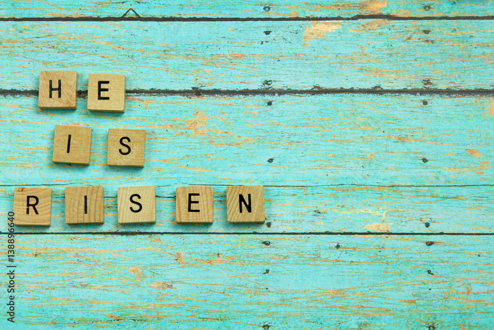 He is Risen Christian blocks on a blue wood plank background Stock ...