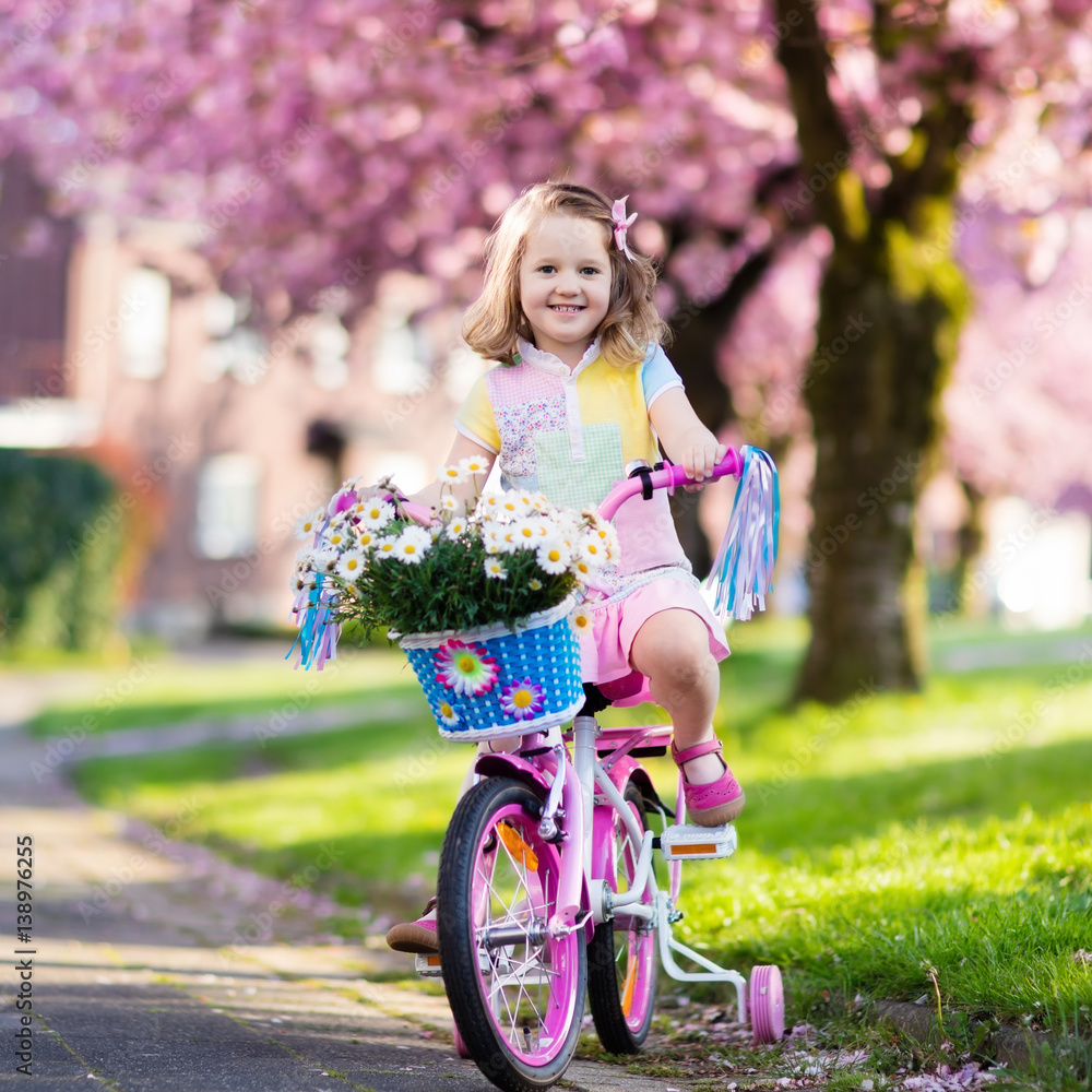 Little girl riding a bike. Child on bicycle. Stock Photo | Adobe Stock