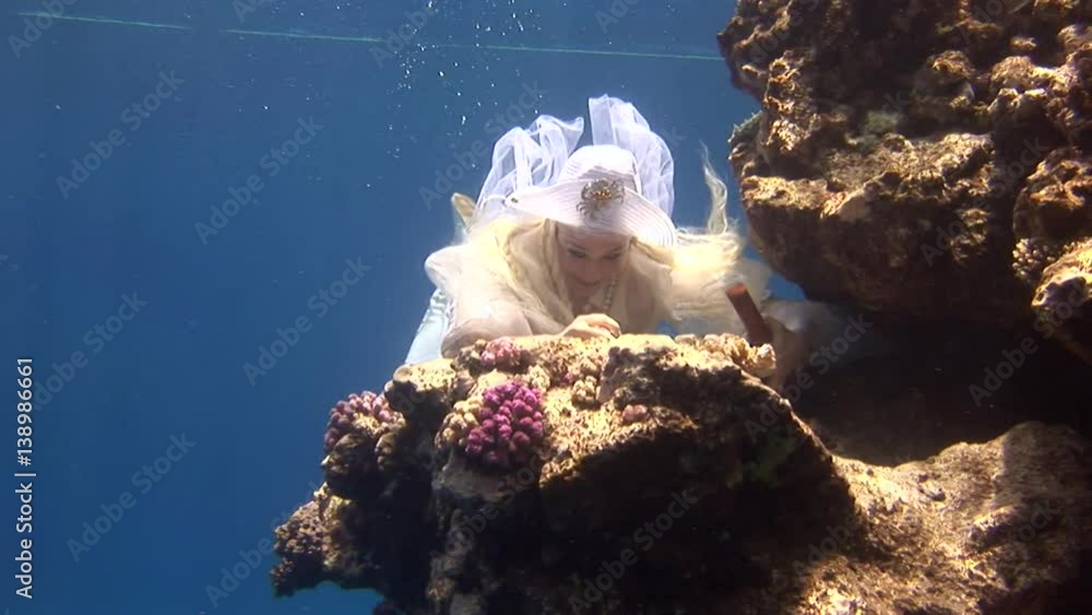 Underwater model free diver in costume pirate swims in clean water in ...