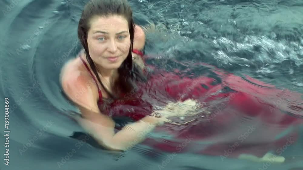 Free diver model in a red dress in water in Red Sea. Filming a movie ...