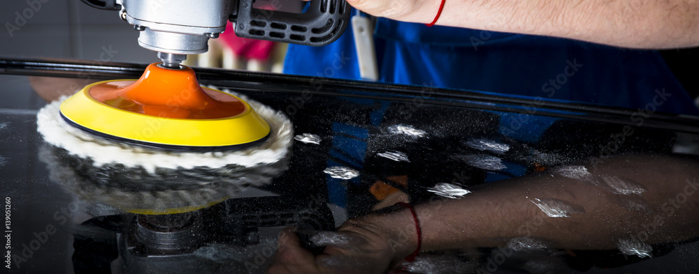 The man is polishing the black car with polish machine. Stock Photo ...