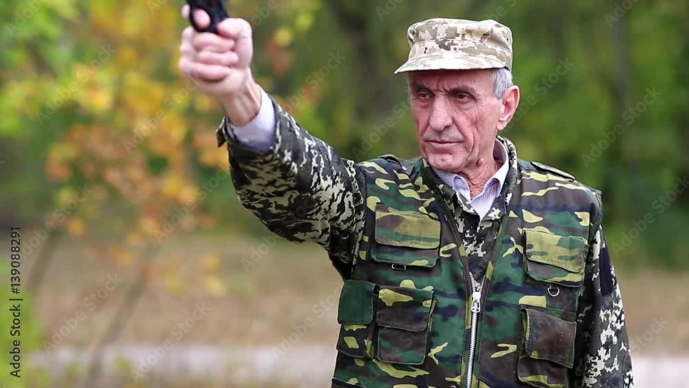 Man in military uniform checks his revolver and shoots. Man with black ...