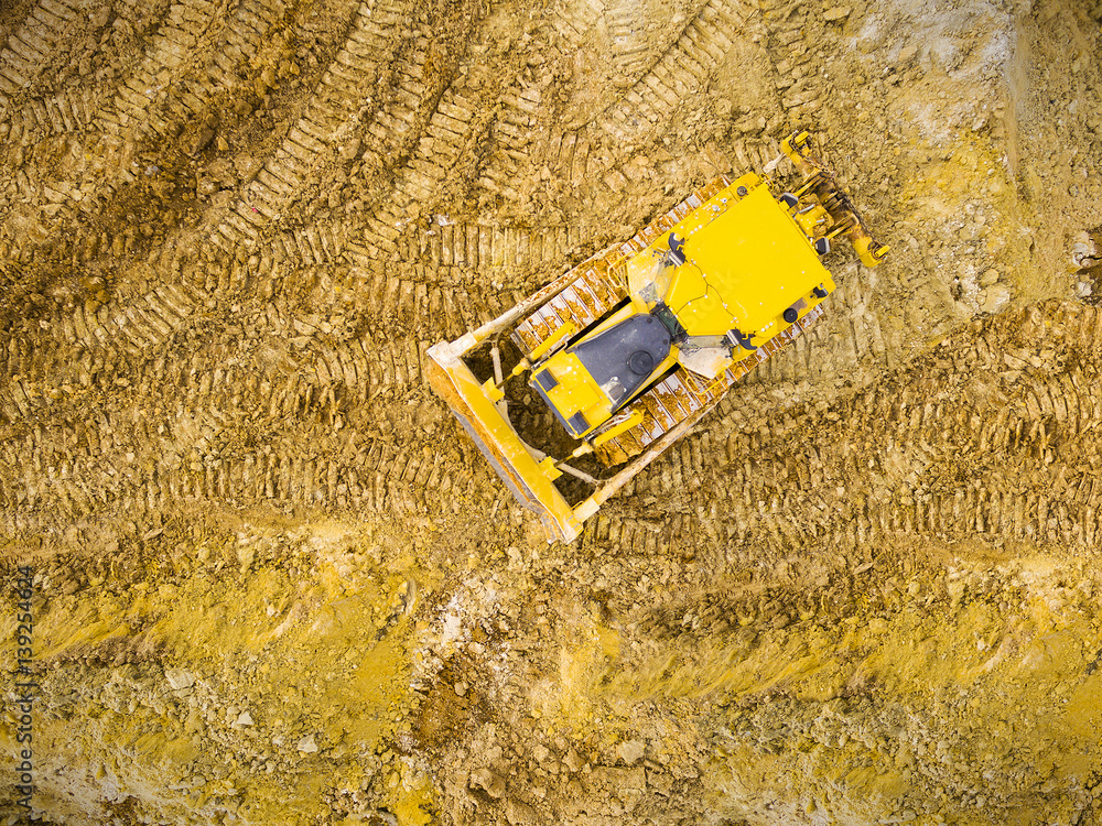 Aerial view of bulldozer on muddy construction site or open cast mine ...