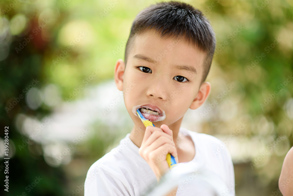 Boy brushing teeth in the garden Stock Photo | Adobe Stock