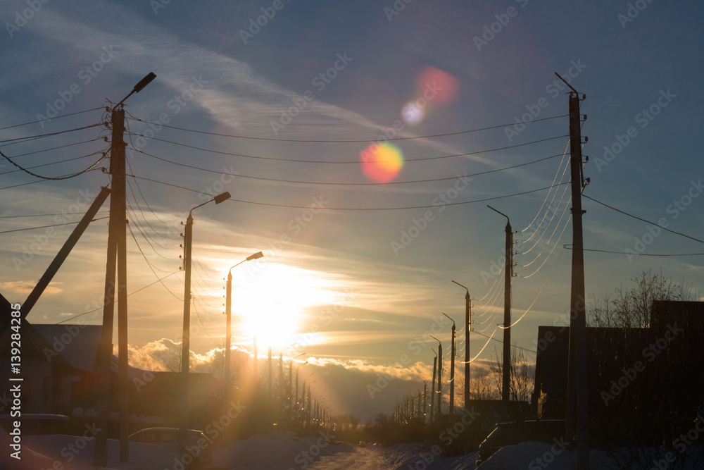 A silhouette of high voltage power lines on colorful sunset background ...