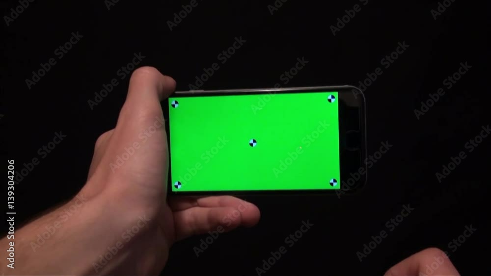 Hand making gestures on a smartphone with green screen chroma, black ...