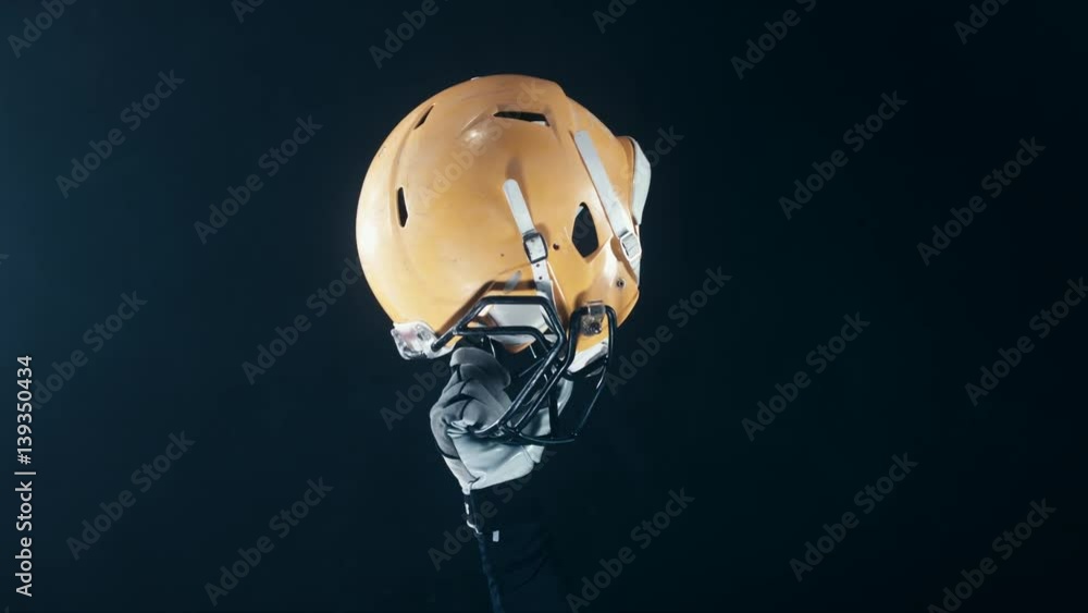 CU Caucasian male American football player rising a helmet in his hand ...