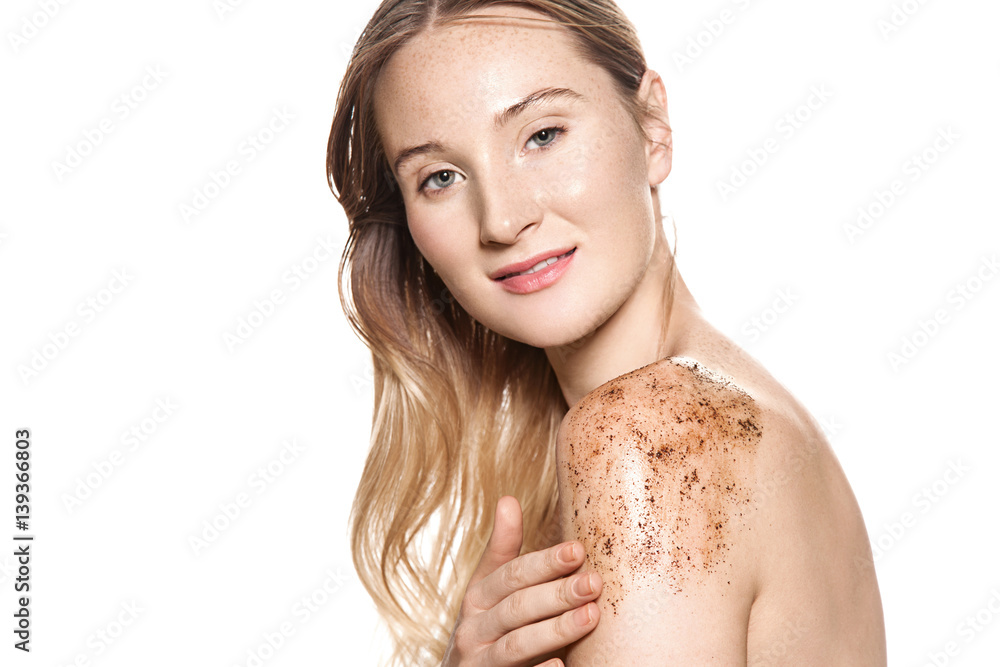 Blonde young woman makes a scrub body peeling on sensitive skin with ...