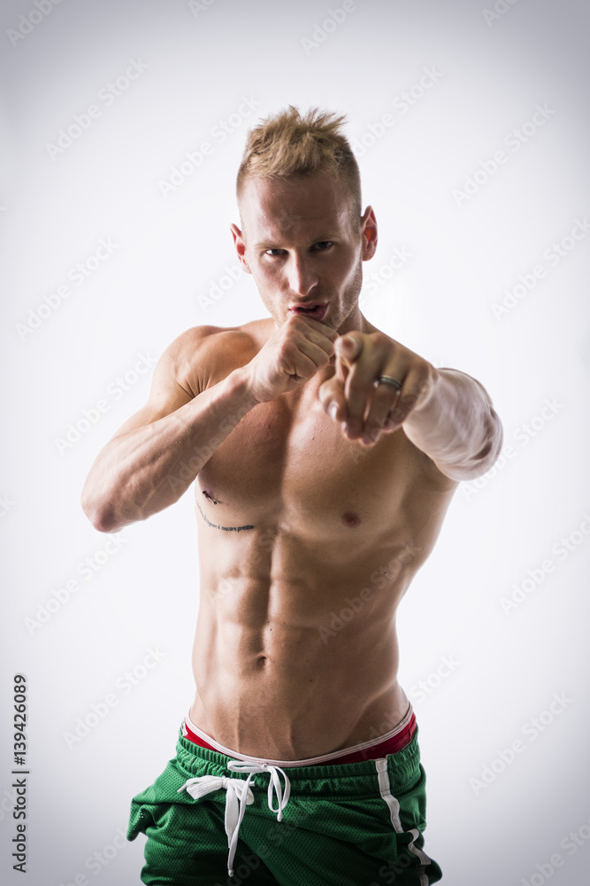 Confident, smiling young man shirtless with muscular torso, ripped abs ...