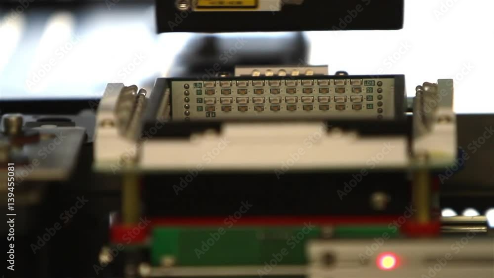 Close-up Surface-Mounting Machine in Progress. SMT (surface-mount technology) is a method for ...