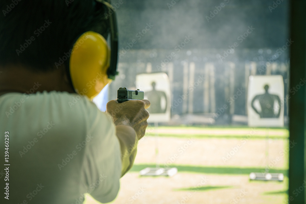 man shooting automatic pistol to target in shooting range Stock Photo ...