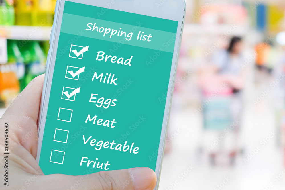 Hand holding smart phone with grocery shopping check list application ...