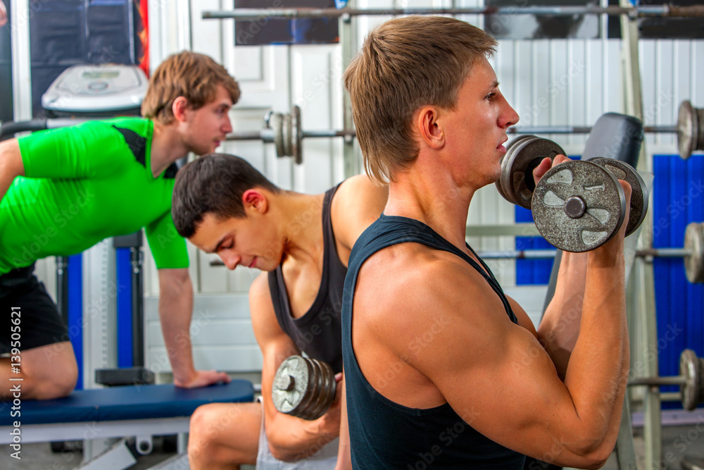 Fitness men friends in gym workout weights with equipment. Muscle man ...