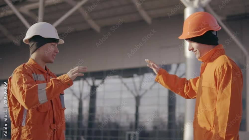 Vidéo Stock Two construction workers high five. They look very happy ...
