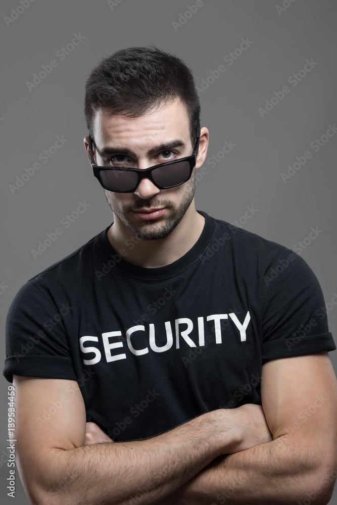 Angry tough male security guard with threatening look above sunglasses ...