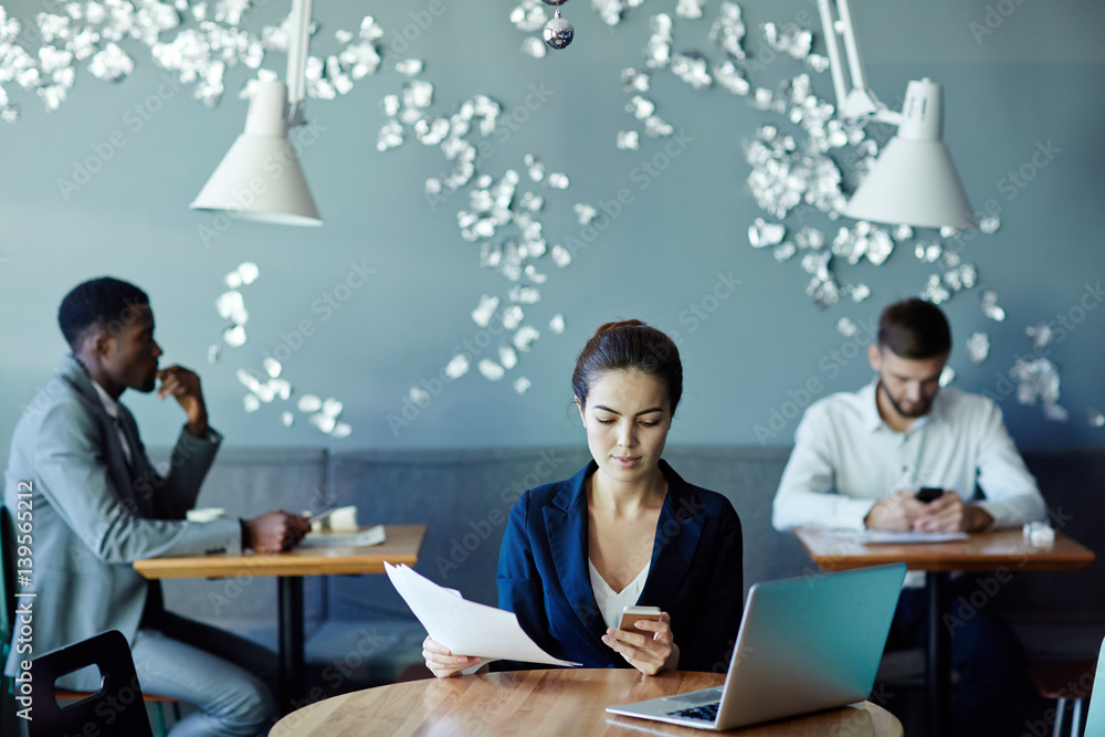 Portrait of elegant young businesswoman sitting at table in cafe and ...
