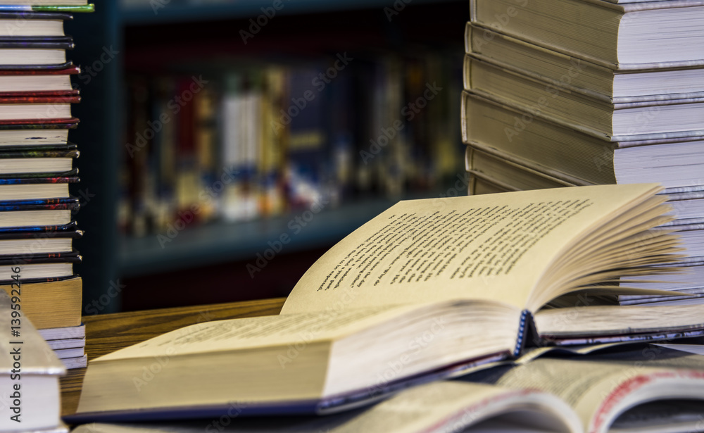 Book in library with old open textbook, stack piles of literature text ...