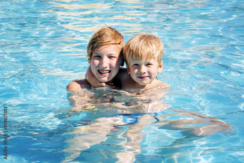Two smiling brothers in the pool.Boys have a good time in aquapark in ...