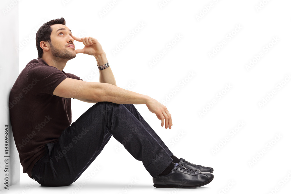 Pensive young man sitting on the floor and looking up Stock-Foto ...