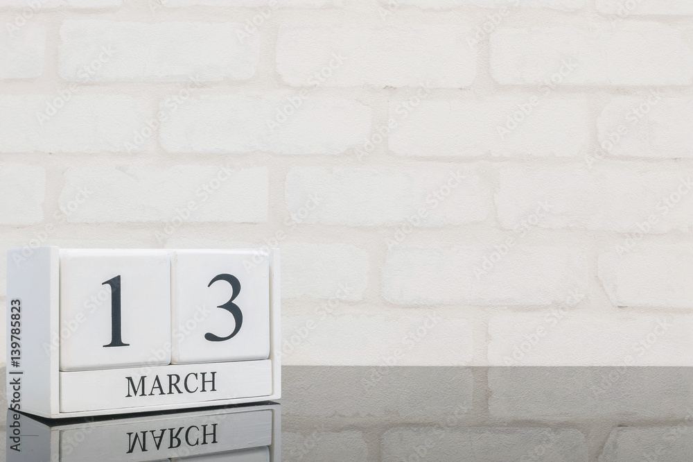 Closeup white wooden calendar with black 13 march word on black glass ...