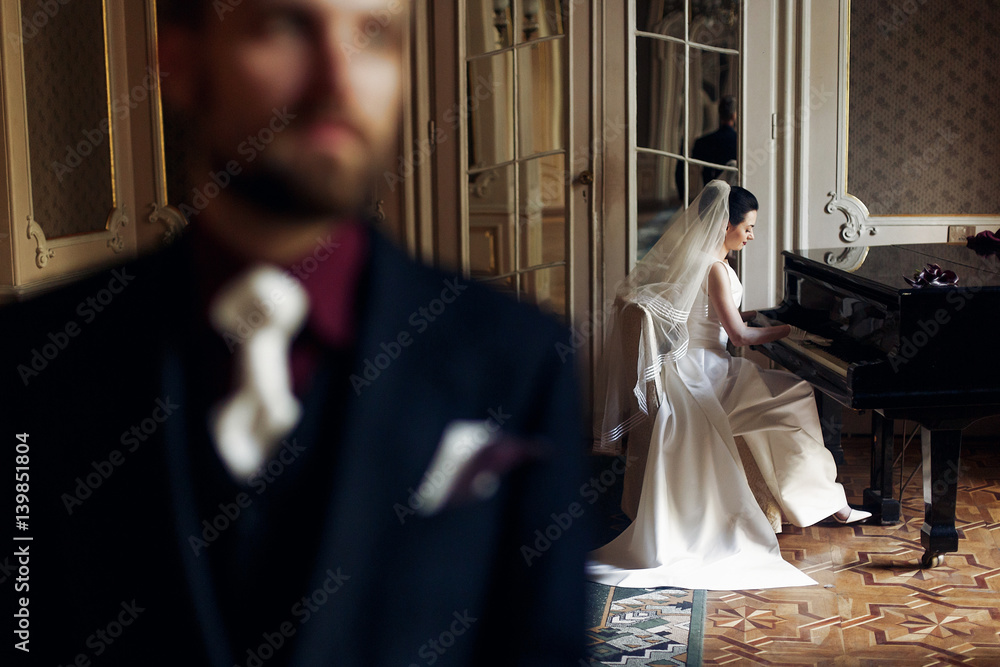 elegant gorgeous bride playing the fortepiano and stylish handsome ...