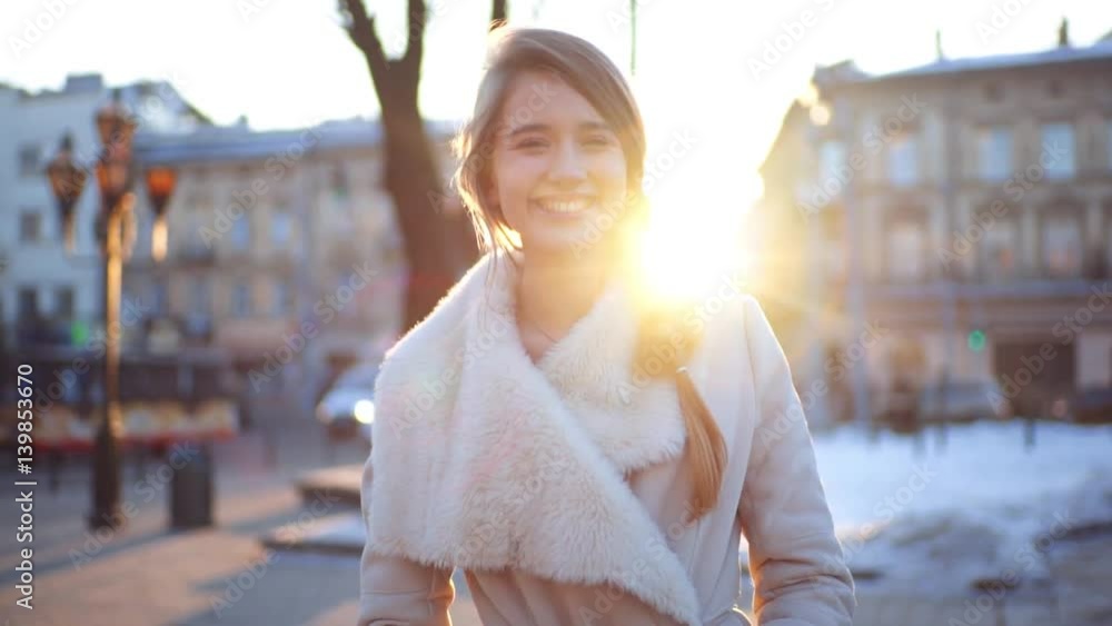A pretty young blonde girl walking in the city center with beautiful ...