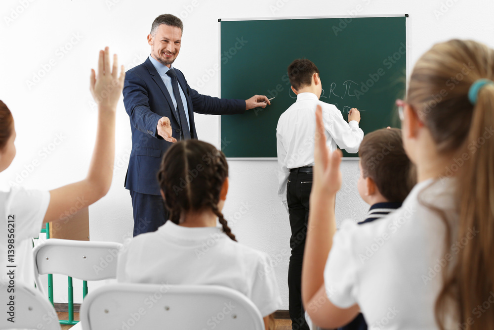 Male teacher conducting lesson in classroom Stock Photo | Adobe Stock