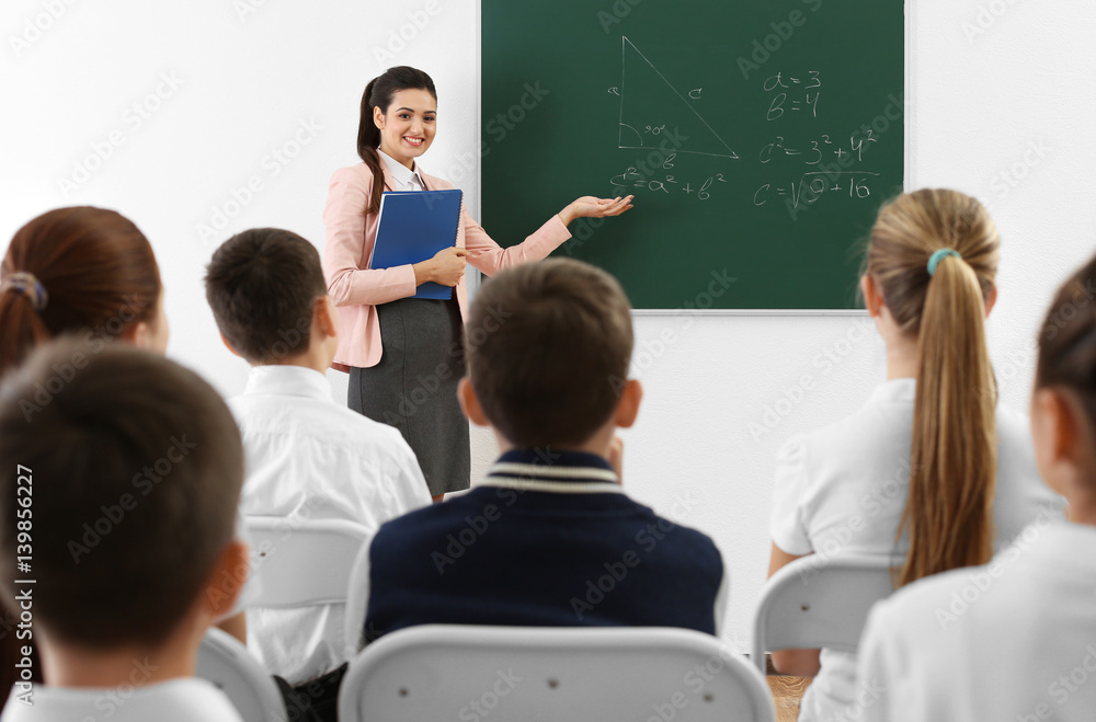 Female teacher conducting lesson in classroom Stock Photo | Adobe Stock