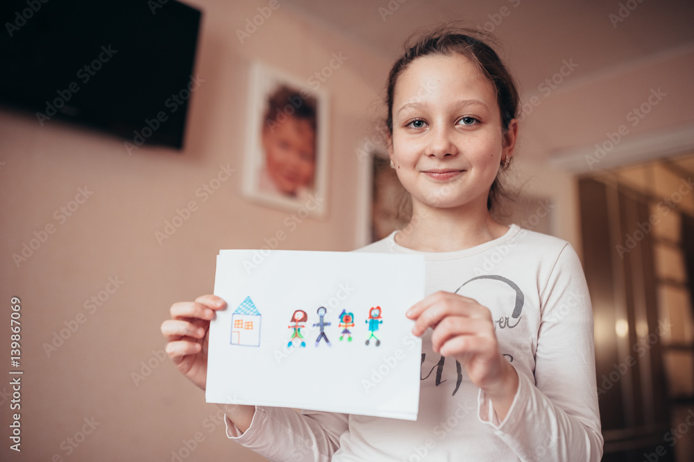 The girl shows her drawing with her family and her house Stock Photo ...