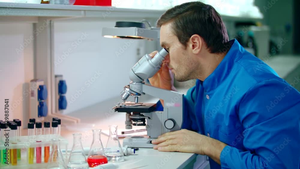 Male scientist doing microscope research. Man scientist looking ...
