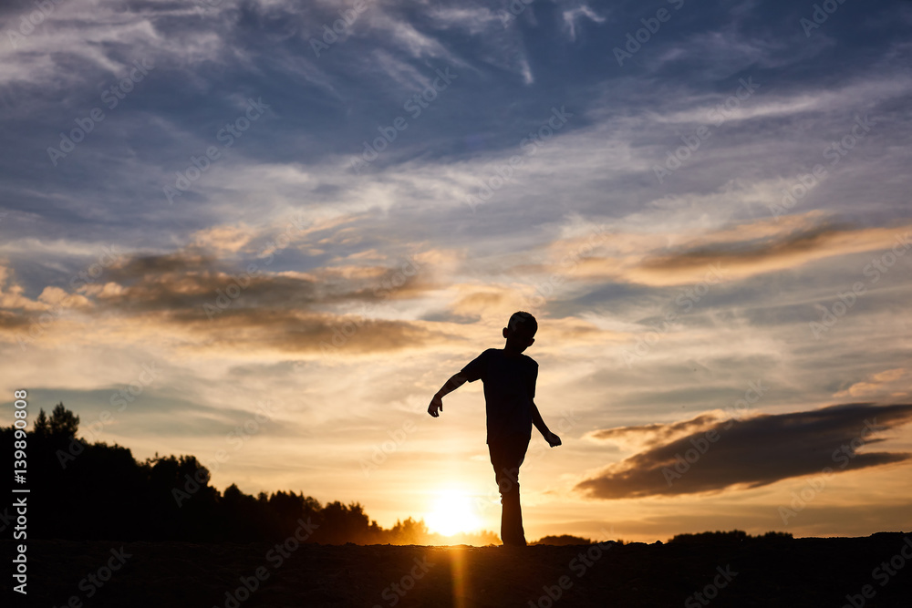 Silhouette boy walking alone in sunset background Stock Photo | Adobe Stock