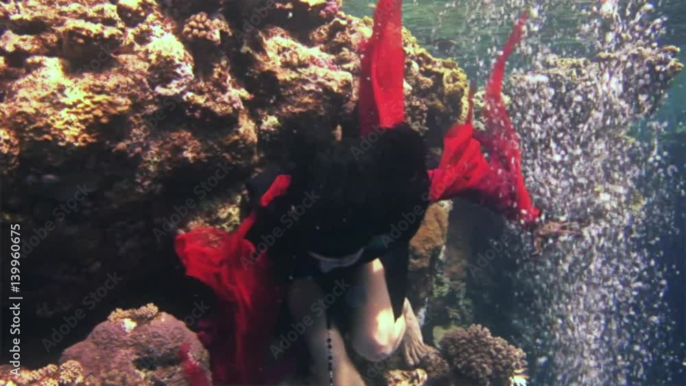 Young girl model free diver underwater in red costume of pirate in Red ...
