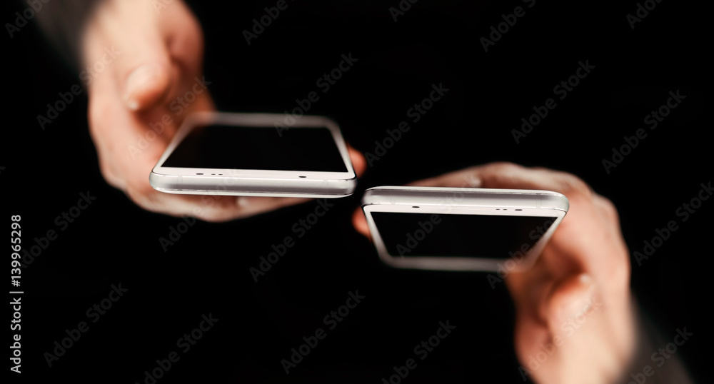 Horizontal view of modern phone, technology concept. Two mens holding ...