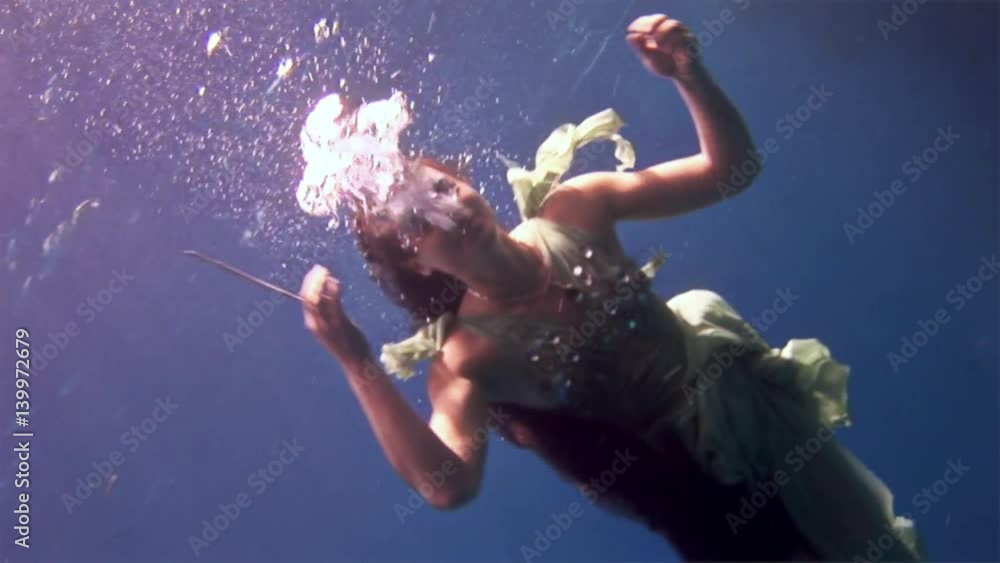 Underwater model free diver in fairy costume on background of corals in ...