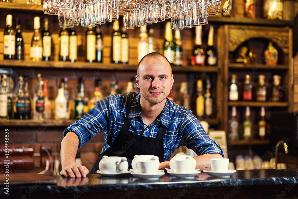 Barman at work in pub,Portrait of cheerful barman worker standing ...