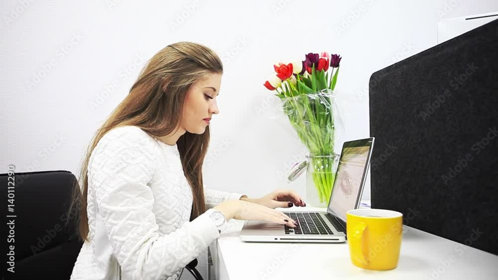Young beautiful pin-up girl sitting behind a desk and working at a ...