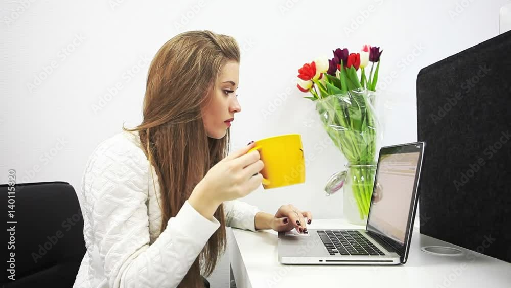 Young beautiful pin-up girl sitting behind a desk and working at a ...