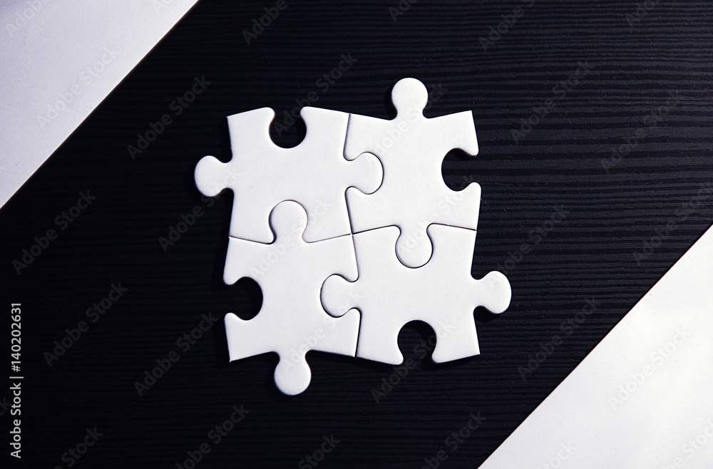 Vier zusammenhängende Puzzleteile auf schwarzem Grund Stock-Foto ...