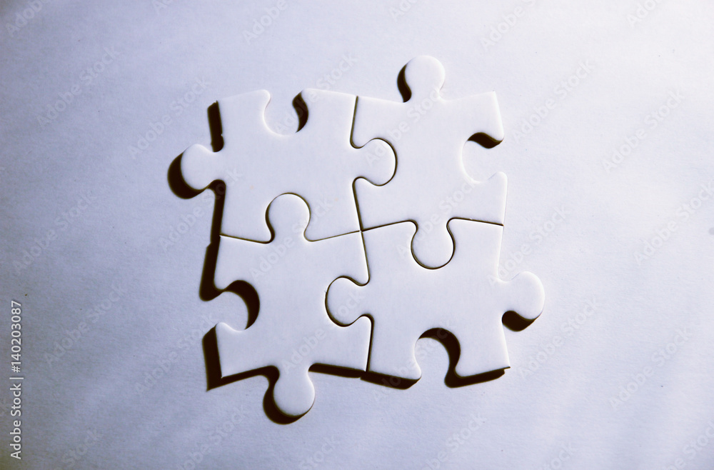 Vier zusammenhängende Puzzleteile auf weißem Grund Stock-Foto | Adobe Stock